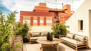 Um pátio com um sofá, cadeiras e uma mesa de centro.