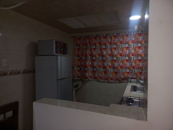 Um frigorífico/congelador grande, um micro-ondas, uma placa de cozinha 