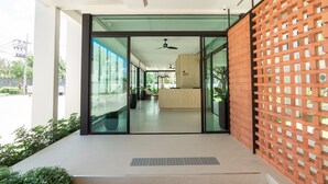 Uma área de recepção moderna com portas de vidro, balcão de atendimento e ventilador de teto.