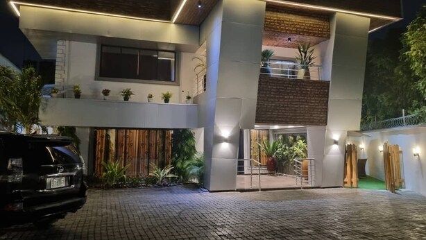 Um edifício moderno de dois andares com fachada de tijolos, janelas amplas e calçada pavimentada.