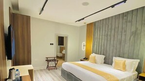 Quarto de hotel moderno com cama, escrivaninha e cadeira.