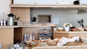 Disposição de buffet com diversos alimentos, peças de vidro e distribuidores de bebidas.