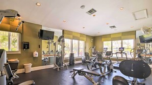 Uma academia com diversos equipamentos de exercício, incluindo esteiras, aparelhos de musculação e um banco prensa.