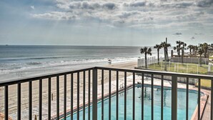 Piscina com vista para a praia e oceano.
