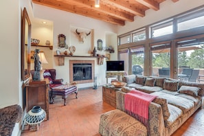 Uma sala de estar aconchegante com lareira, assentos confortáveis e uma grande janela com vista para o exterior.