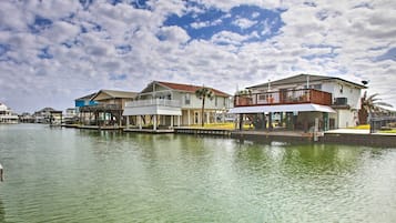 Um imóvel à beira-mar com um cais, área coberta e um edifício com varanda.