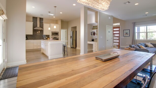 Uma cozinha espaçosa com ilha central, eletrodomésticos modernos e um lustre.