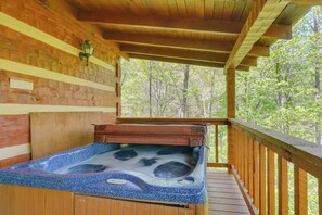 Uma banheira de hidromassagem em uma cabana de madeira com vista para uma floresta.