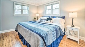 Quarto com uma cama grande, duas luminárias de cabeceira e uma mesa de cabeceira.