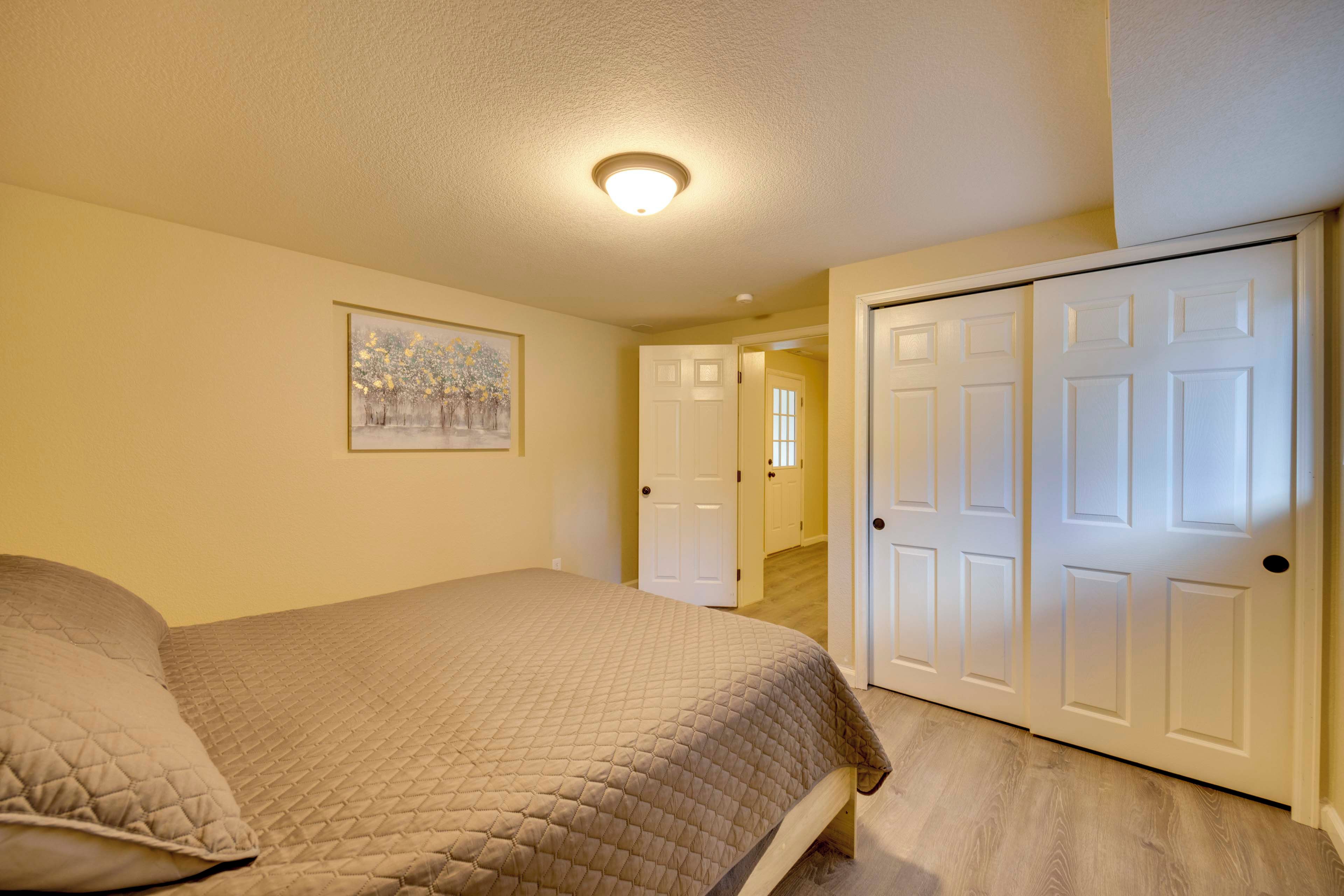 Quarto com cama, uma porta e corredor que dá para outro cômodo.