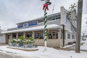 Um edifício com uma placa que diz “PIZZERIA & BAR GRILL” e um enfeite de Natal.