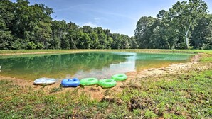 Um lago límpido com anéis flutuantes verdes e azuis na margem.