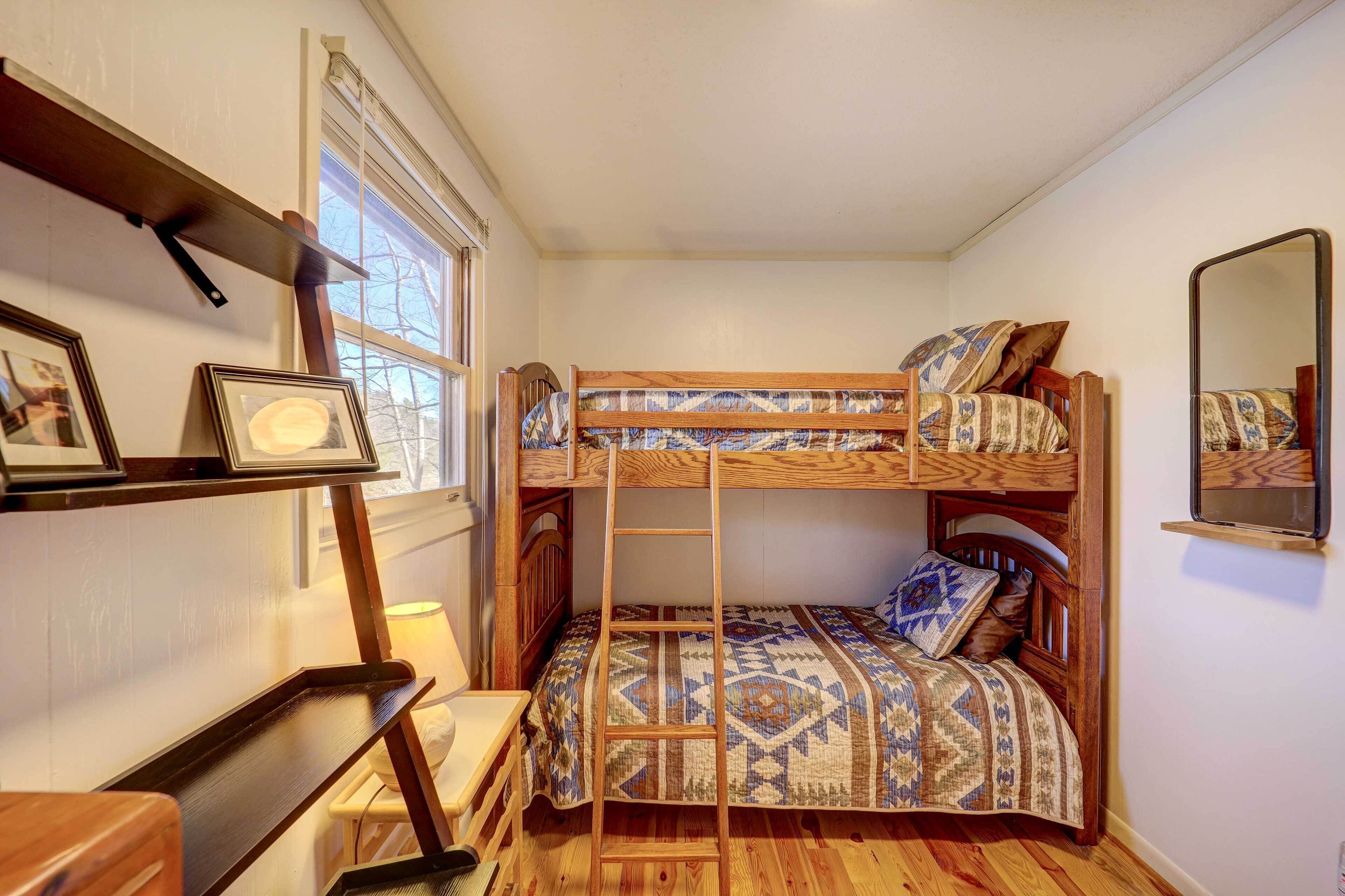 Quarto com beliche, escrivaninha e espelho na parede.