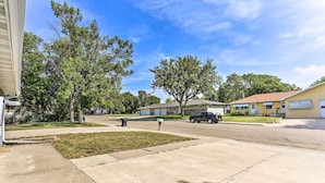 Rua residencial com casas, entrada de automóvel e caixa de correio.