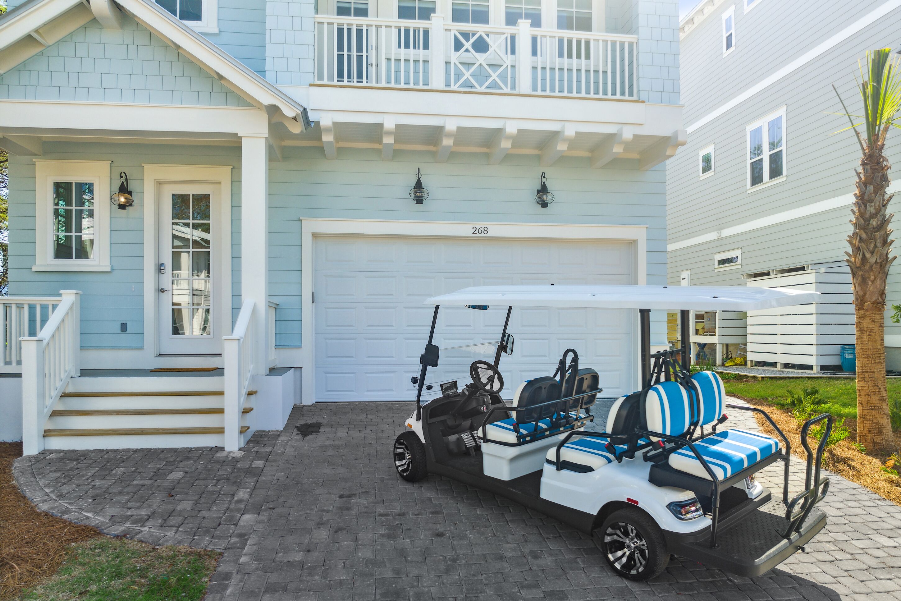Uma casa de dois andares com garagem número 268, um alpendre frontal e um carrinho de golfe estacionado na frente.