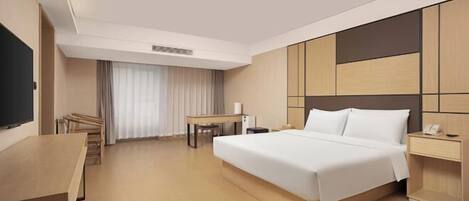 Quarto de hotel com uma cama grande, uma escrivaninha, uma cadeira, uma televisão e um guarda-roupa.