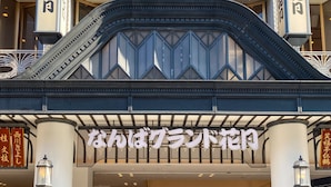 Fachada de edifício com entrada destacada e sinalização.
