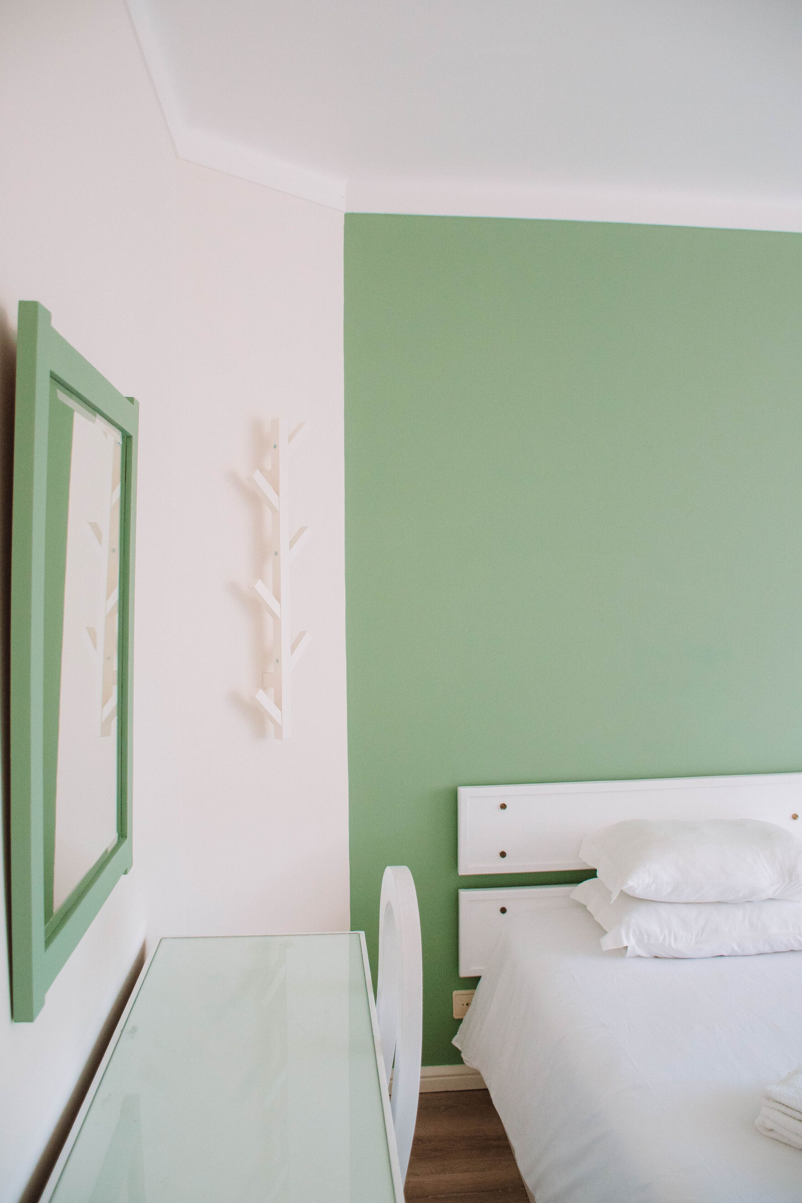 Um quarto com uma cama, uma mesinha de cabeceira e uma prateleira na parede.