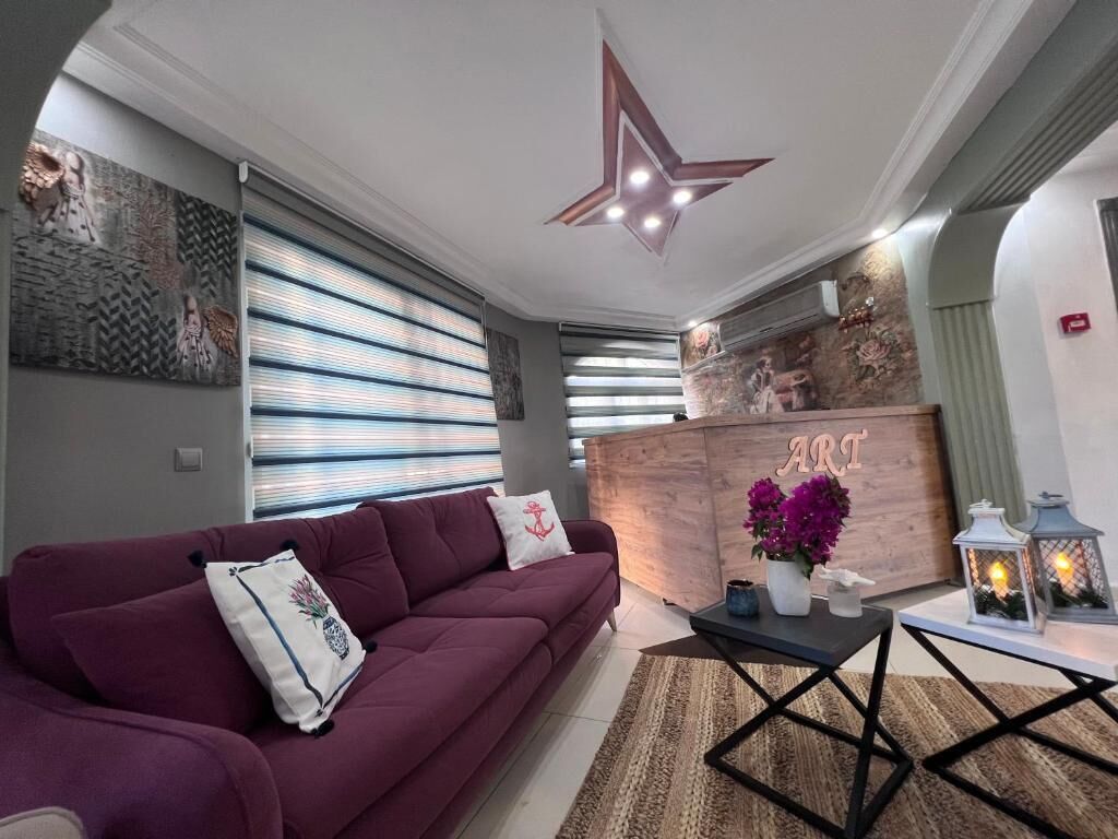 Uma sala de estar moderna com um sofá, uma mesa de centro e um objeto decorativo na parede.