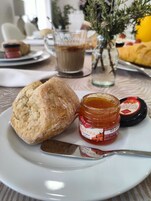 Um prato com um biscoito, um pote de doce de abóbora e uma colher.
