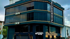 Um edifício moderno de hotel com fachada escura e várias janelas.