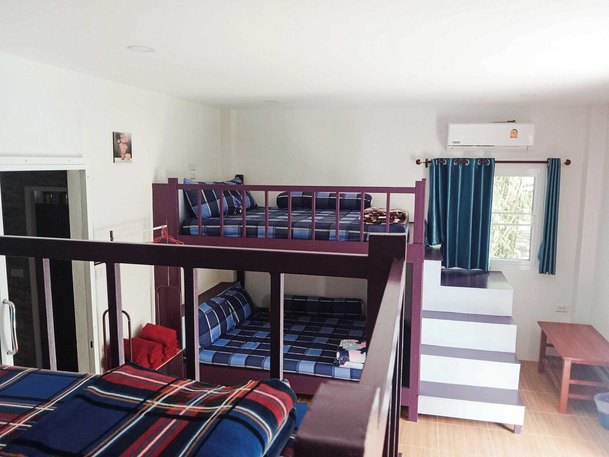 Quarto com beliche, janela, um banco e escada.