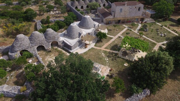 Um edifício de pedra com várias estruturas em forma de cone e um pátio.