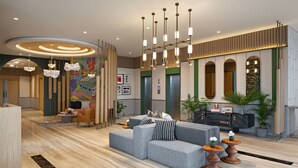 Um lobby moderno com sofá cinza, detalhes em madeira e um mural colorido.