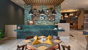 Um restaurante moderno com balcão central, vigas de madeira no teto e um mural vibrante.