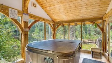 Uma banheira de hidromassagem em uma cabana de madeira com vista para a floresta.