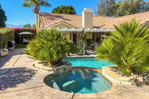 Uma casa com piscina, móveis de pátio e cadeira de balanço.
