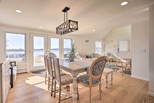 Uma área de refeições com uma mesa de madeira, cadeiras e um lustre.