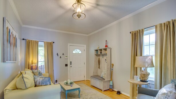 Uma sala de estar com um sofá, uma mesa de centro e uma mesa lateral com uma luminária.