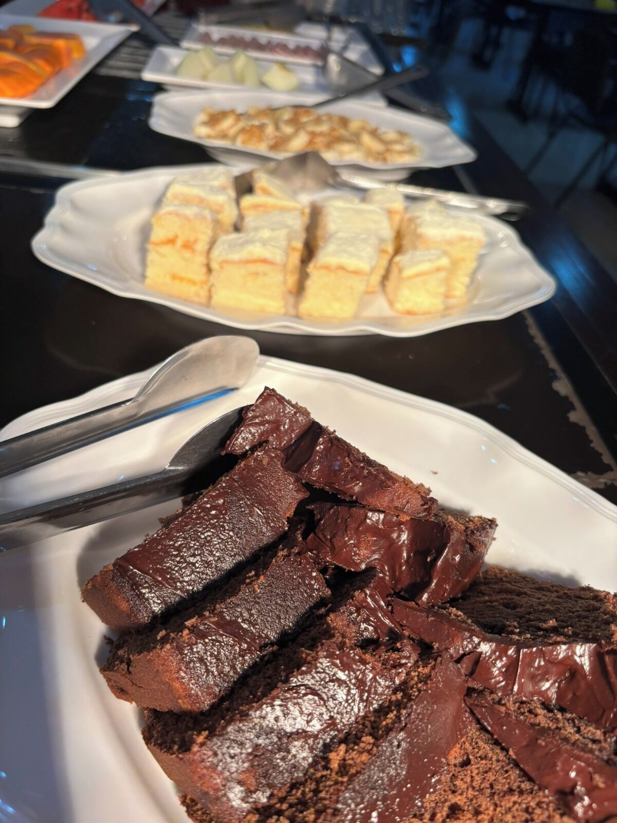 Mesa de buffet com diversos doces, incluindo brownies e pastelaria.