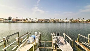 Marina com barcos atracados e fileira de casas ao fundo.