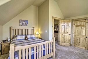 Quarto com cama de madeira, mesa de cabeceira, luminária e armário com portas de madeira.