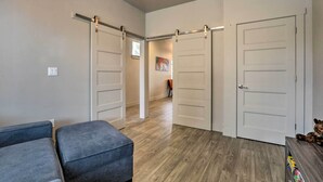 Um interior moderno com portas de correr, um sofá e piso de madeira.