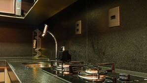 Cozinha com pia de aço inoxidável, torneira e fogão.