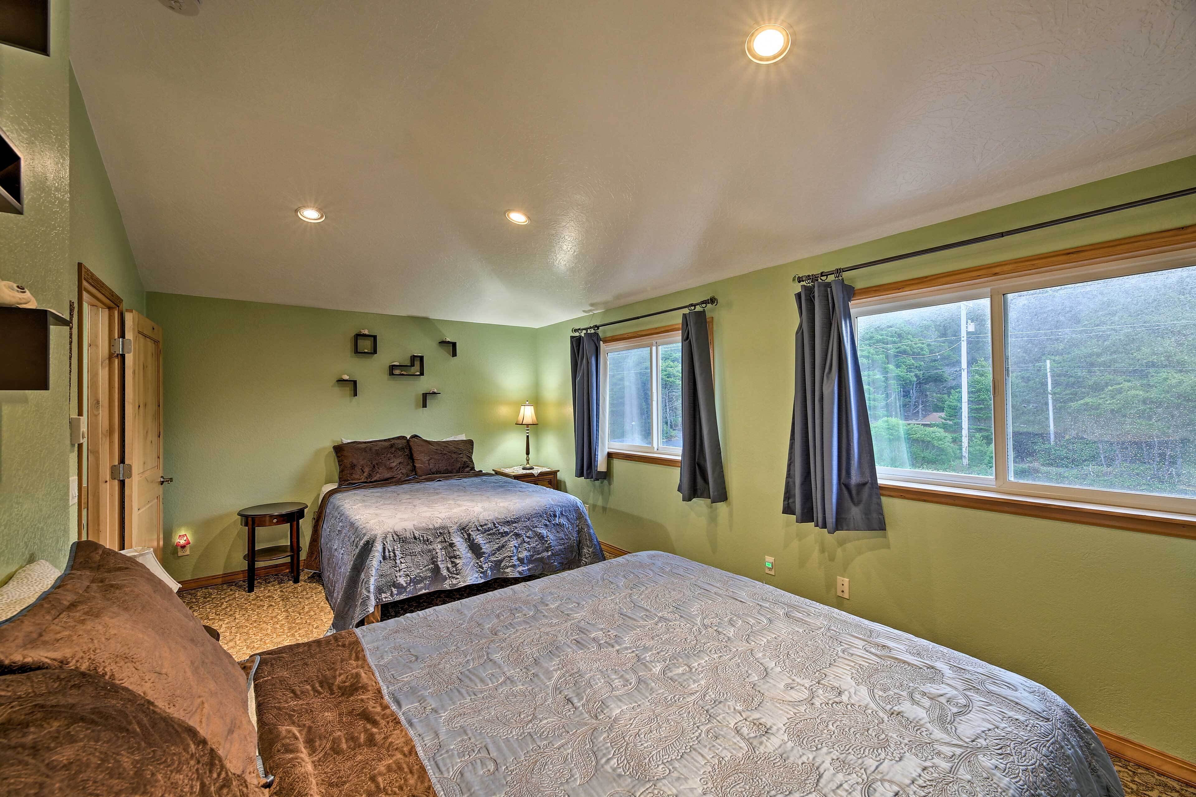 Quarto com duas camas, uma janela com cortinas, uma mesa de cabeceira e um nicho na parede.