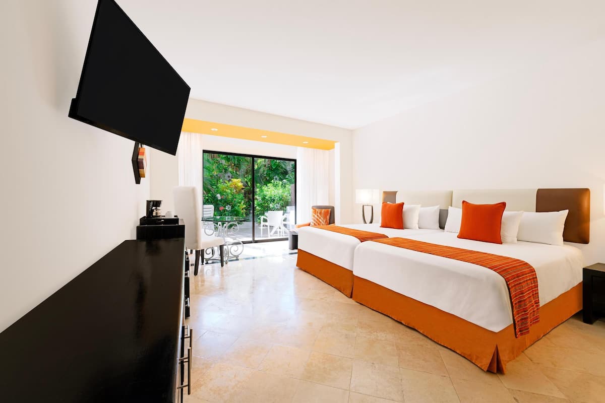 Quarto de hotel moderno com uma cama grande, televisão de tela plana, área de refeições com vista e varanda.