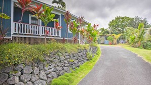 Uma casa com parede de pedra e plantas tropicais.