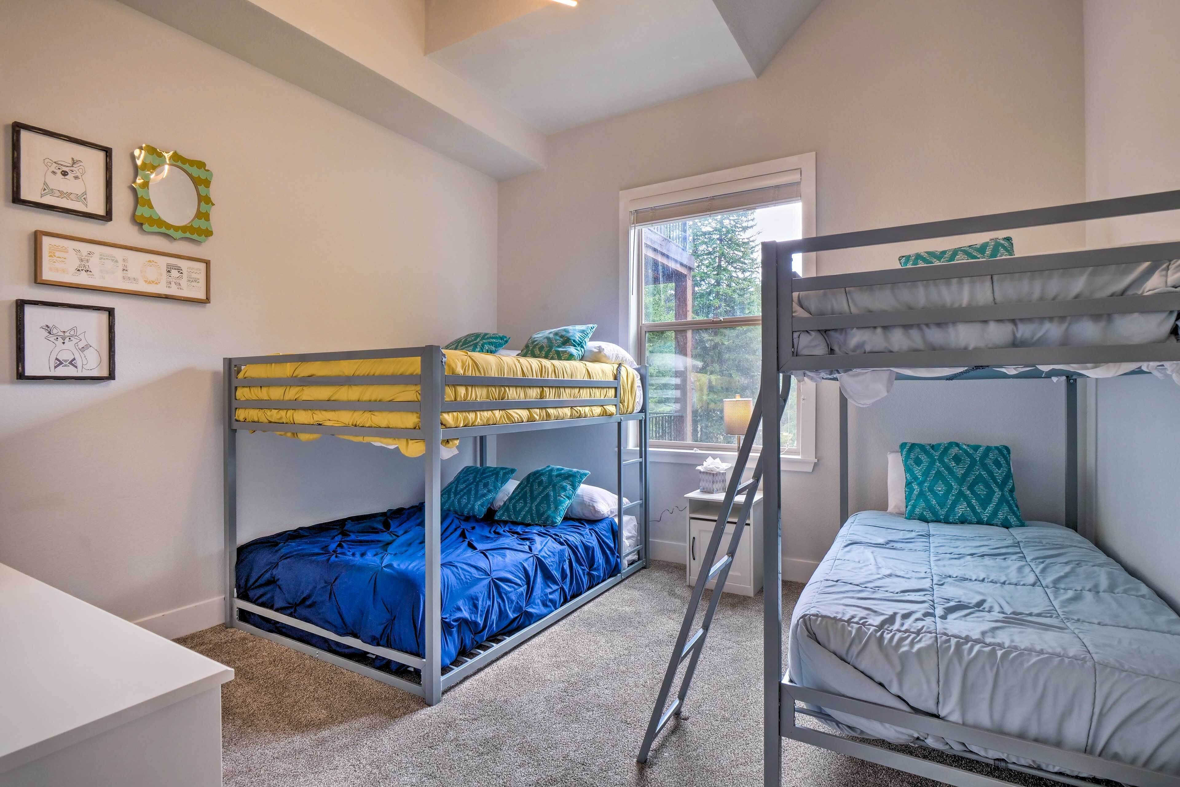 Quarto de dormitório com beliches, escrivaninha e janela.