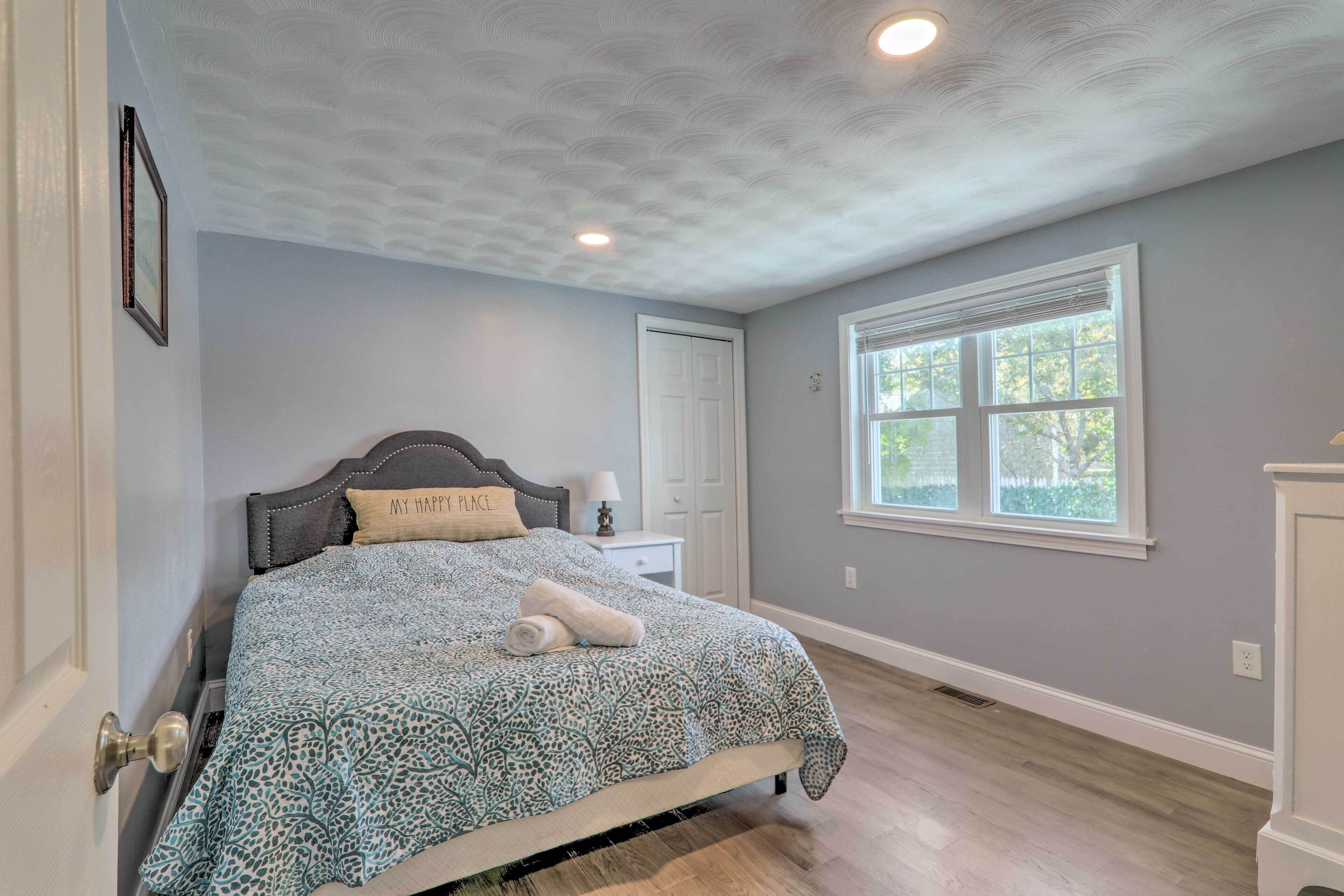 Um quarto com uma cama, uma janela e uma porta.