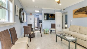 Uma sala de estar com sofá, mesa de centro e um espaço de refeições com cadeiras e mesa.