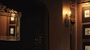 Uma área de estar acolhedora com um sofá, uma mesa de centro com objetos decorativos, uma planta em vaso e iluminação embutida na parede.