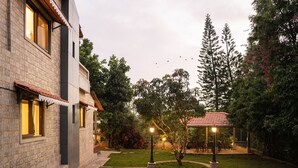 Um pátio com um gazebo, um gramado bem cuidado e um edifício com fachada de tijolos.
