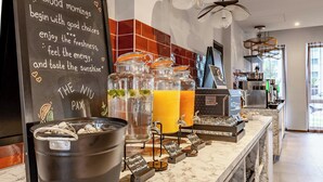Uma mesa de pequeno-almoço com um quadro negro, dispensadores de vidro e uma máquina de café.