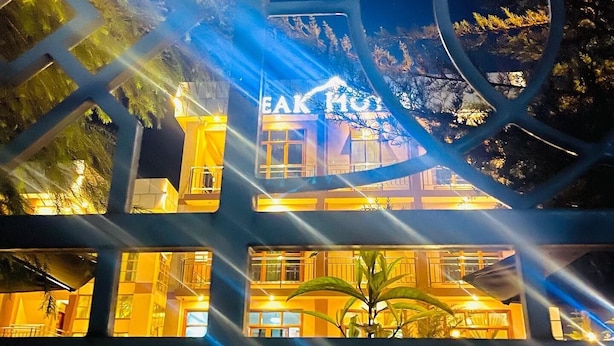 Um hotel com vários andares, sinalização iluminada e varandas.