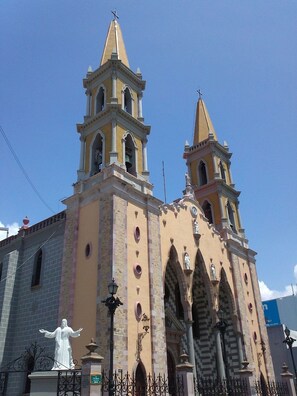 Uma igreja com duas torres sineiras e uma estátua na frente.