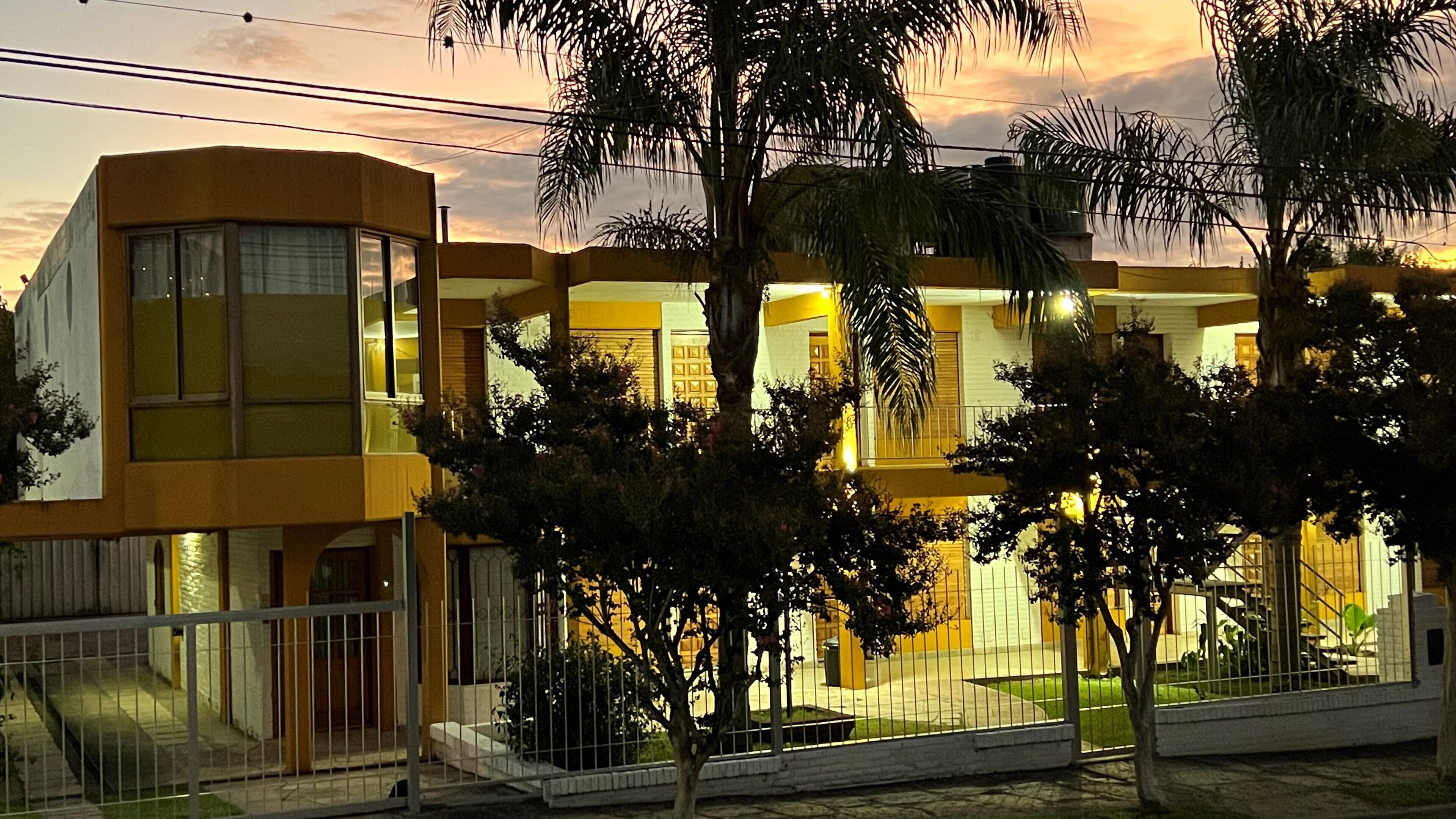 Um edifício moderno com várias varandas e entrada com portão.